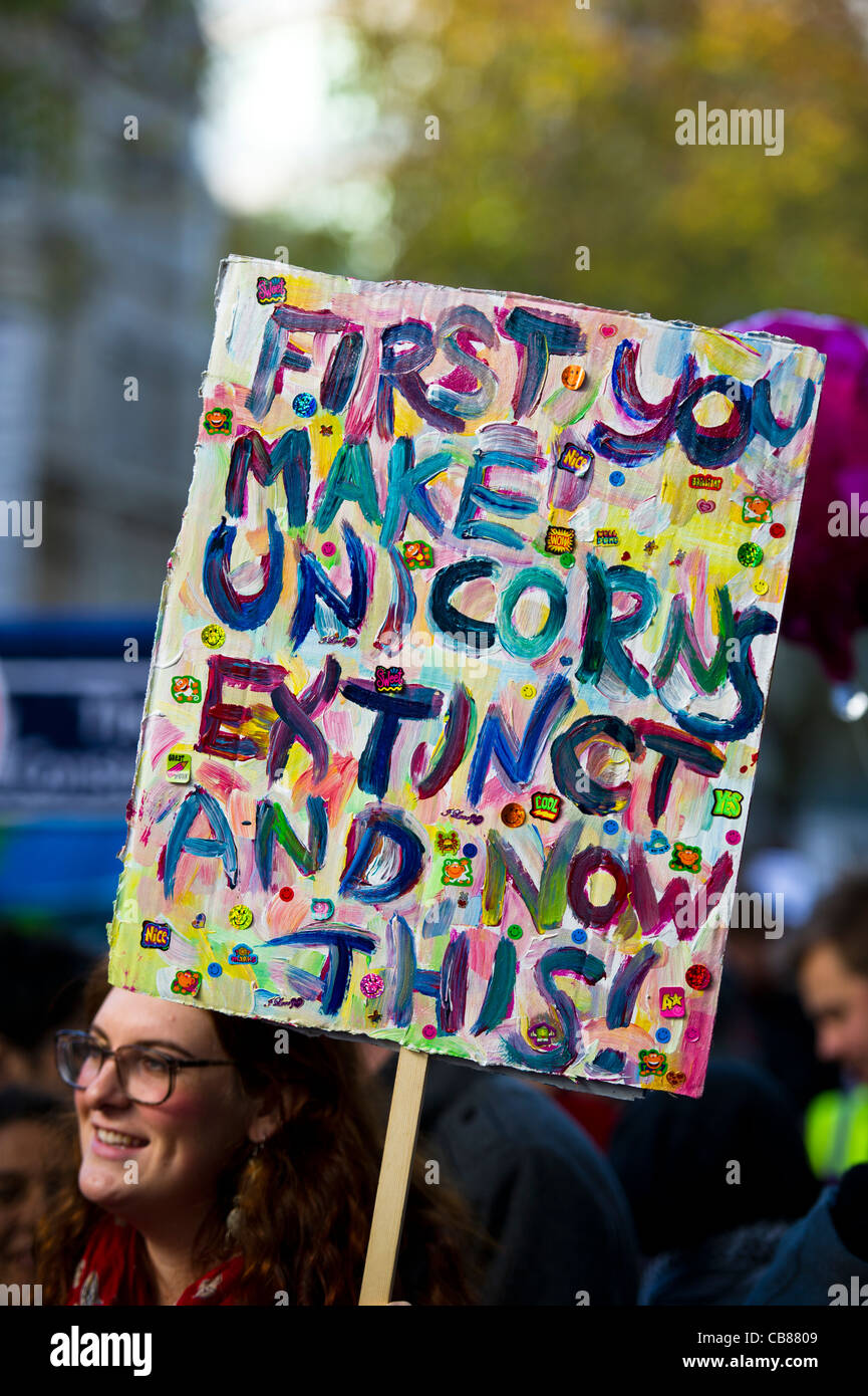 Smiling female protester holding placard with colourful writing ...