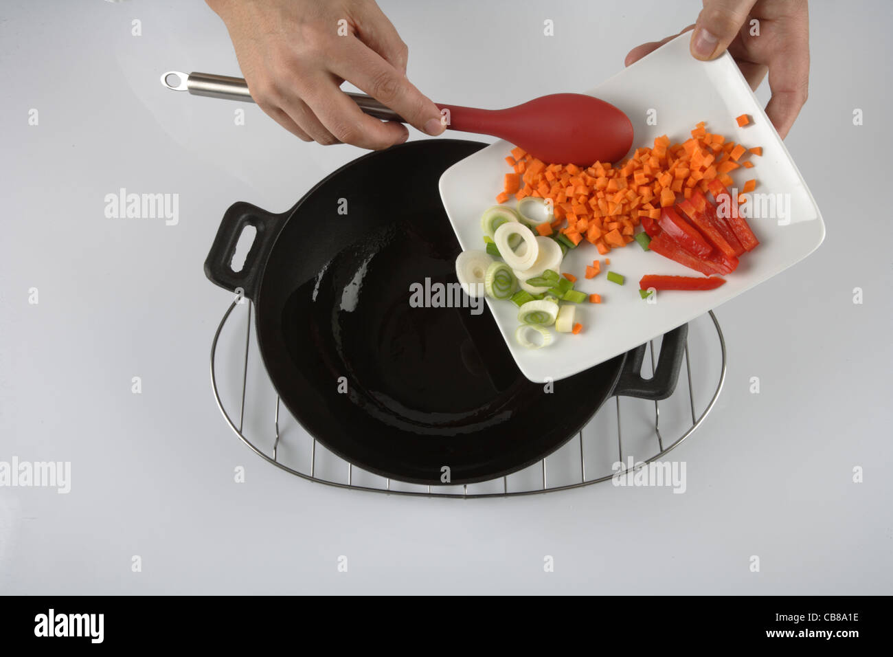 Adding vegetables to a pan Stock Photo - Alamy
