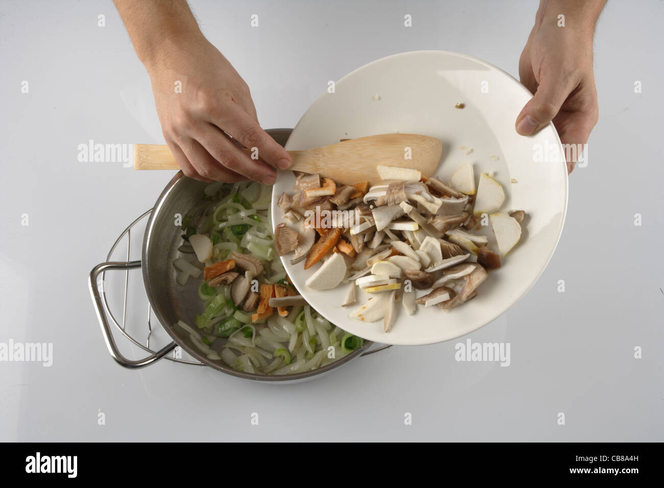 Adding sliced mushrooms Stock Photo - Alamy
