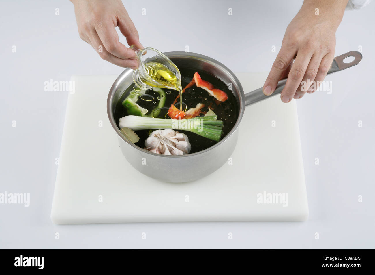 Adding olive oil over the beans and vegetables Stock Photo - Alamy