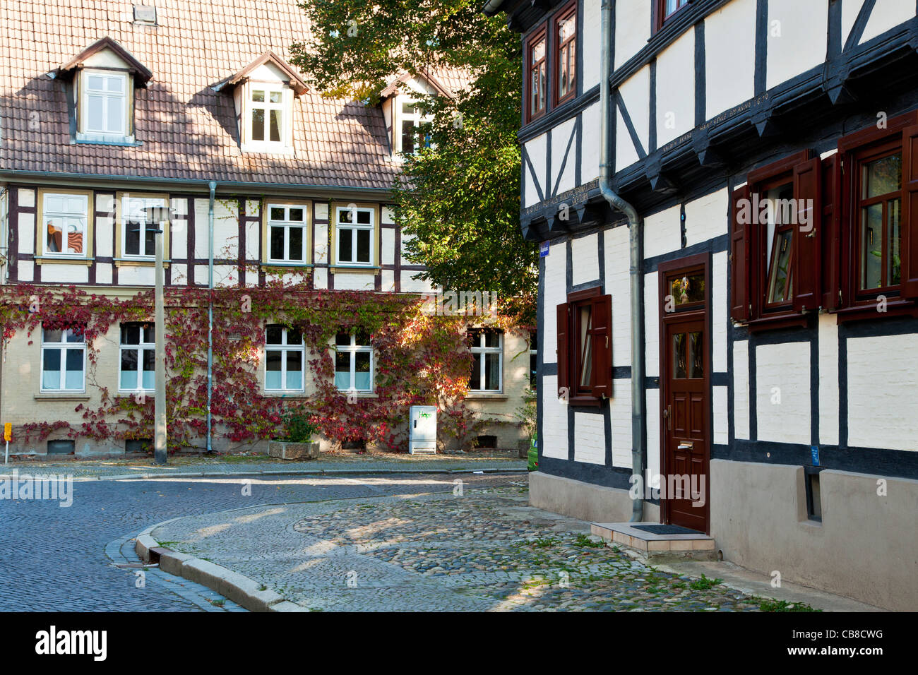 A street corner of half-timbered medieval houses in a cobbled street in ...