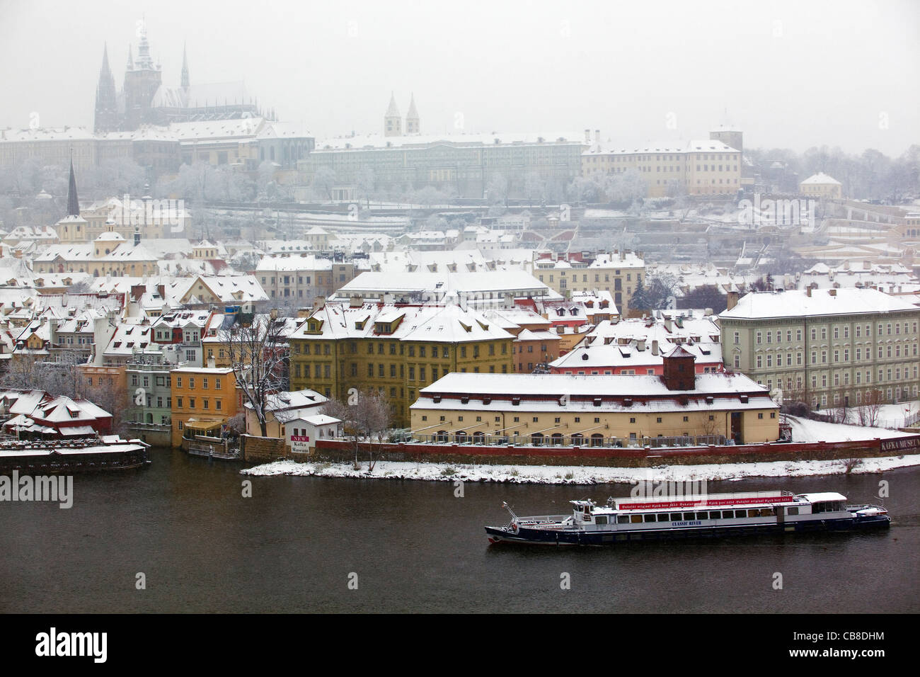 Prague castle covert in mist and snow covered roofs of Mala Strana seen ...