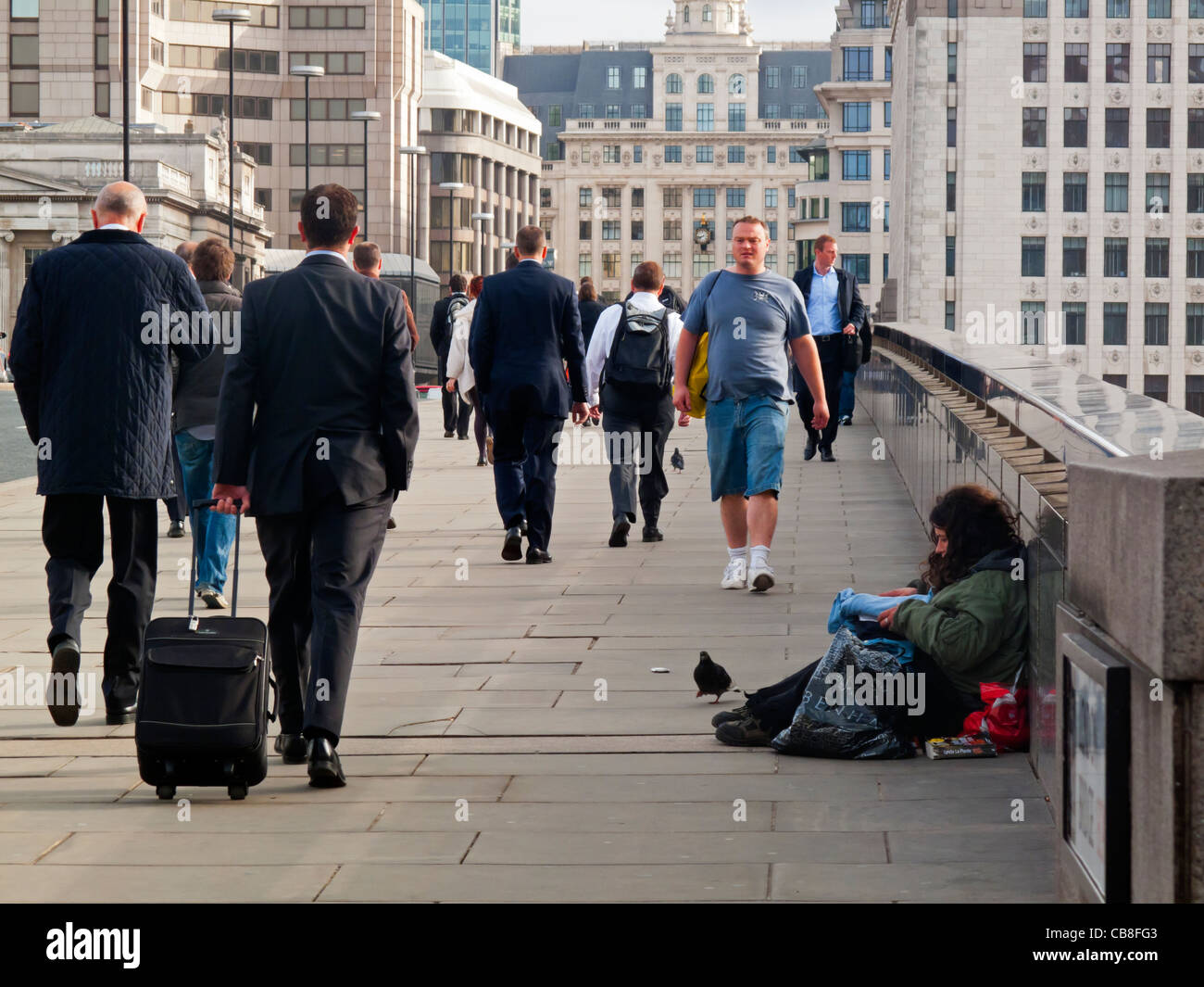 Office workers and commuters crossing London Bridge in City of London ...