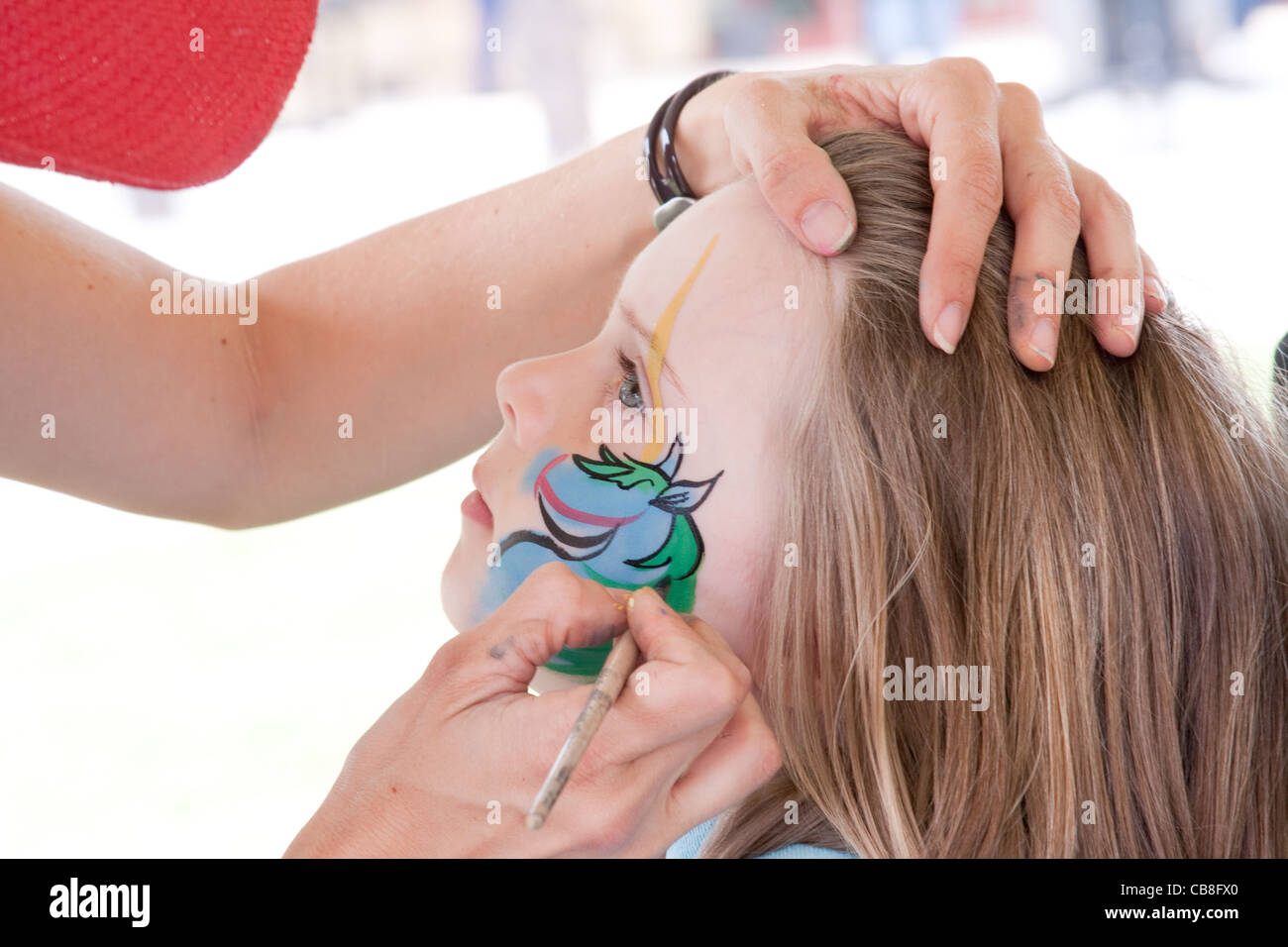Young Girl getting her face painted at a festival Stock Photo - Alamy