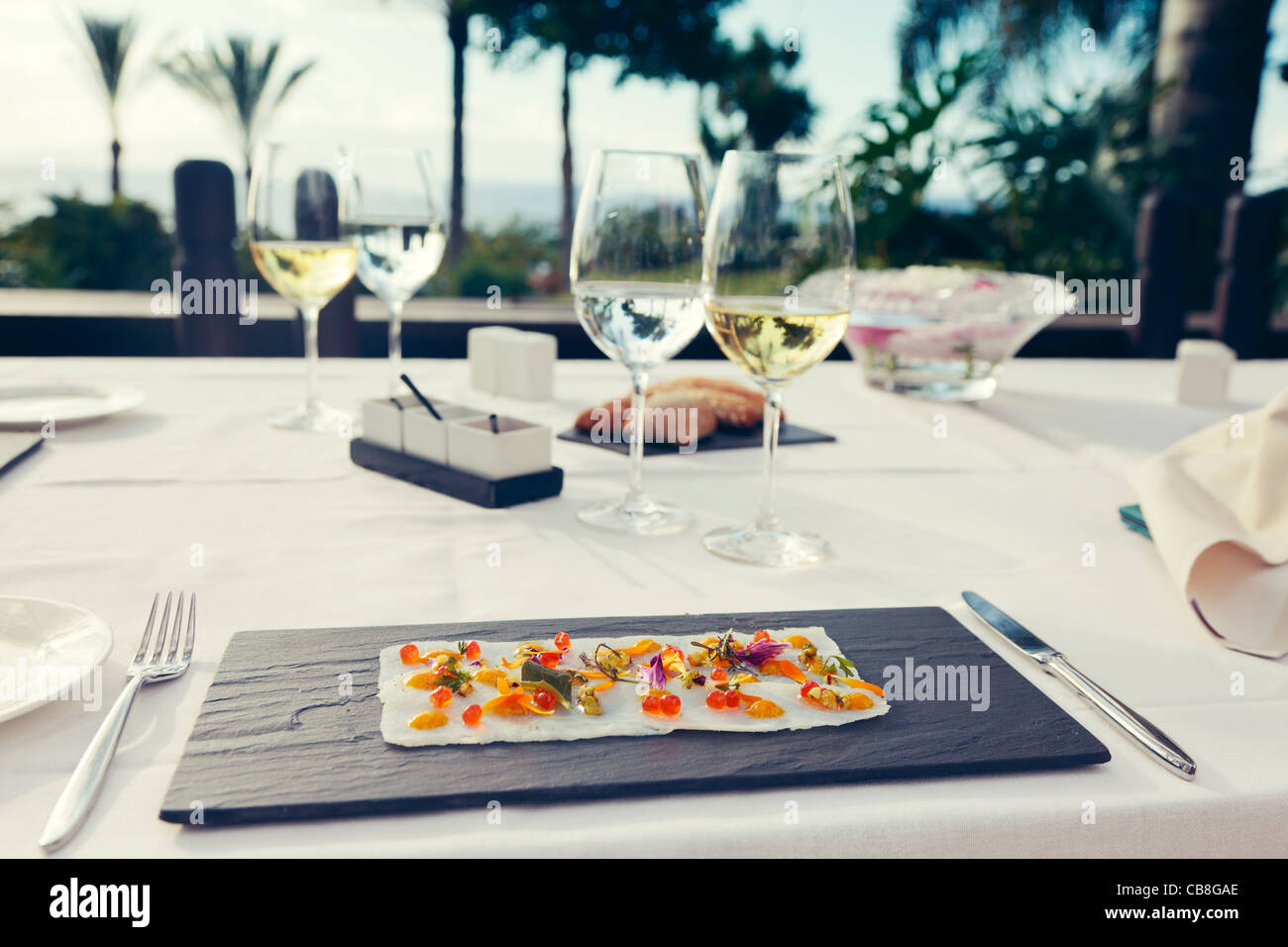 Cod carpaccio served on a slate plate outdoors in tenerife Stock Photo ...