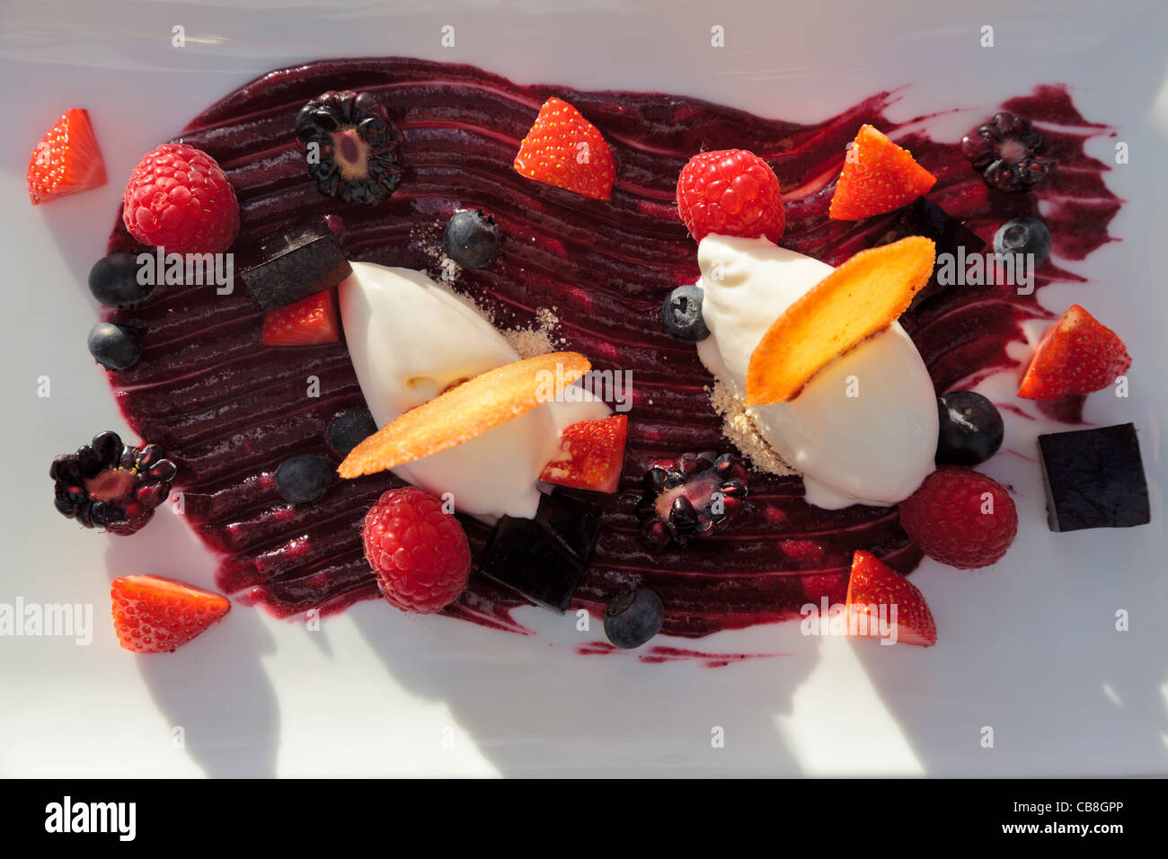 A red fruit dessert with ice cream and biscuit Stock Photo - Alamy