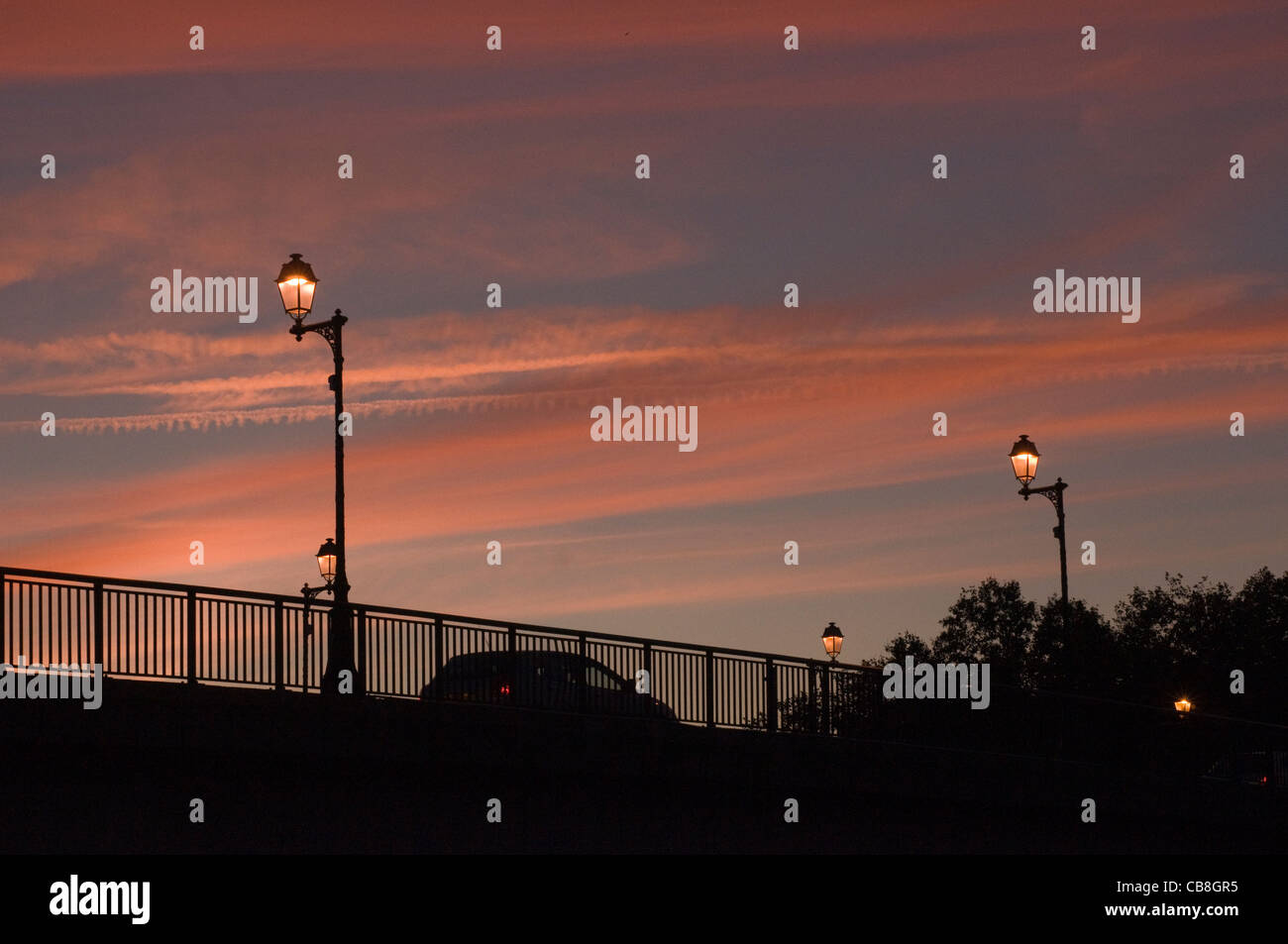 Sunset over bridge in Agde showing passing car Stock Photo - Alamy