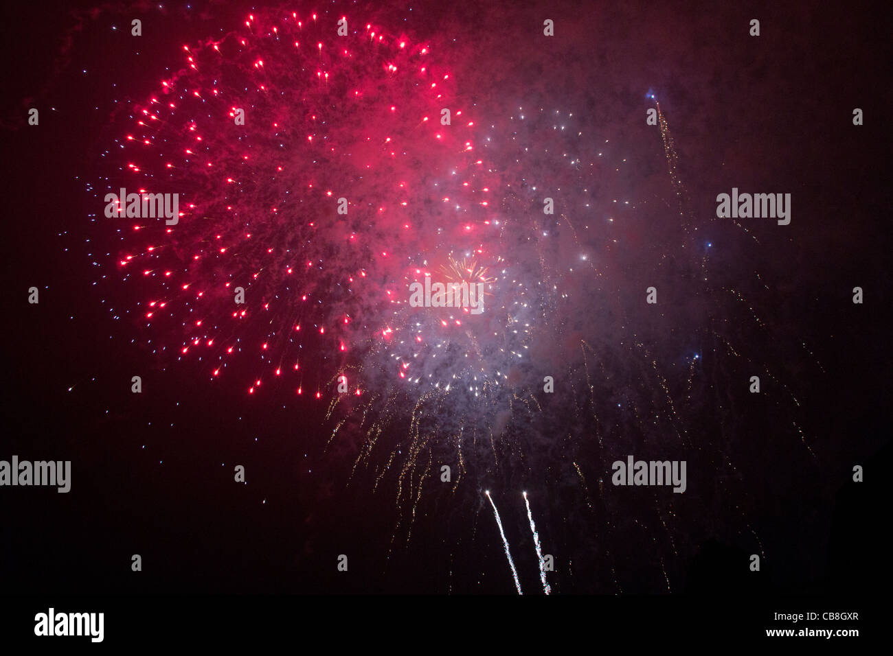 Huge red firework explosion with smaller explosions in the background ...