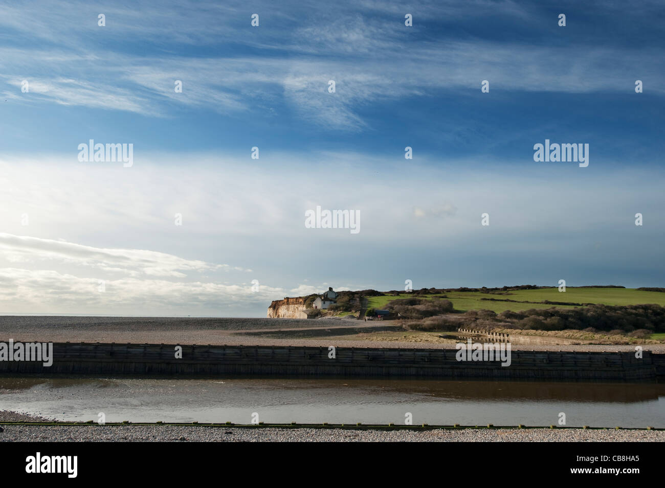 The River Cuckmere running between wooden levees close to the sea at ...
