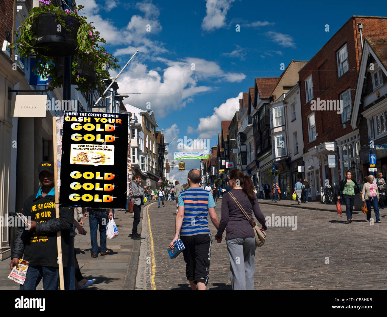 GOLD CASH SIGN Traditional Guildford High Street and shoppers with man ...