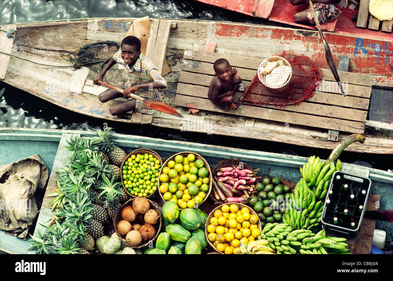 River Niger delta, Bendel State, Nigeria. Boys sell fruit and beer from ...