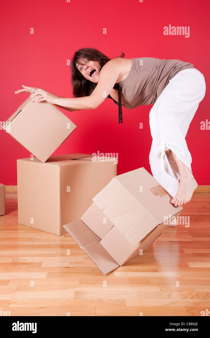 young woman trying to hold some cardboard boxes from falling Stock ...