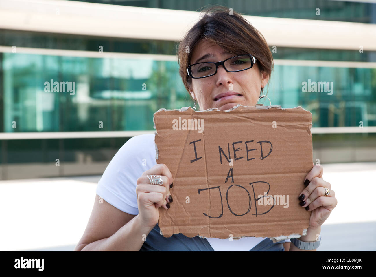 unemployed woman showing a message in a cardboard that she needs a job ...