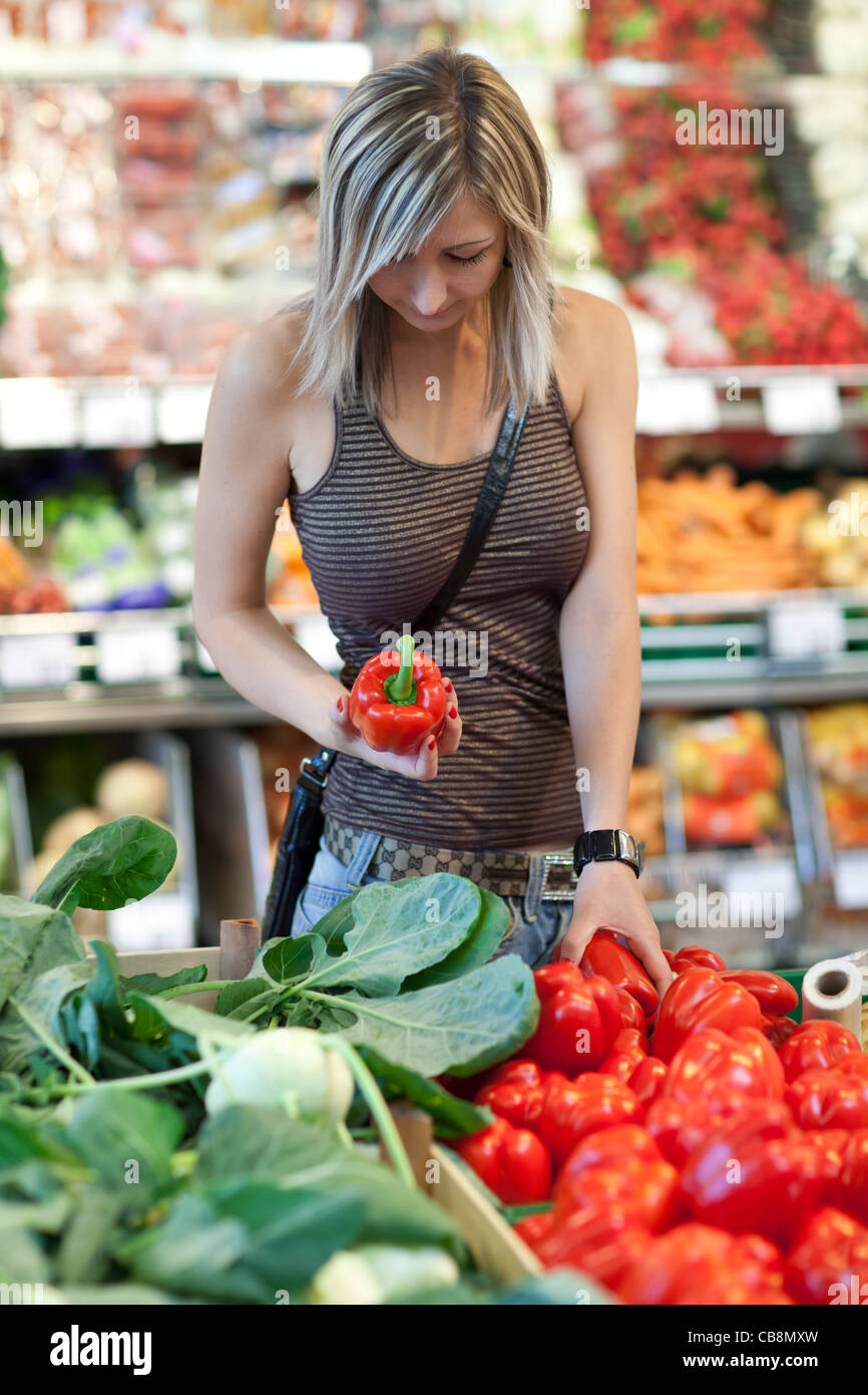 Beautiful young woman shopping for fruits and vegetables in produce ...