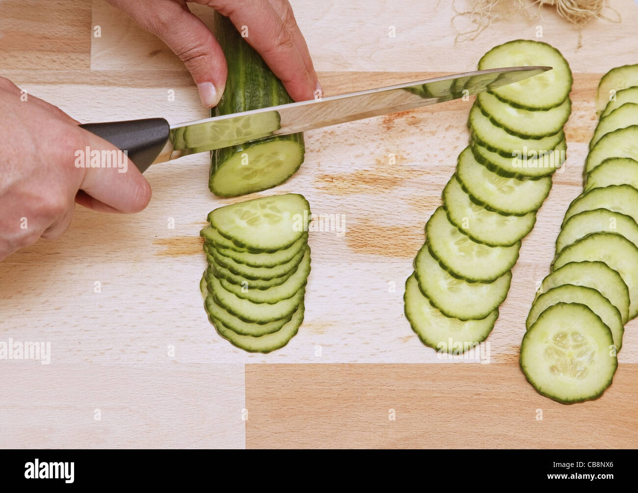 Upper view of hands with a knife chopping a cucumber Stock Photo - Alamy