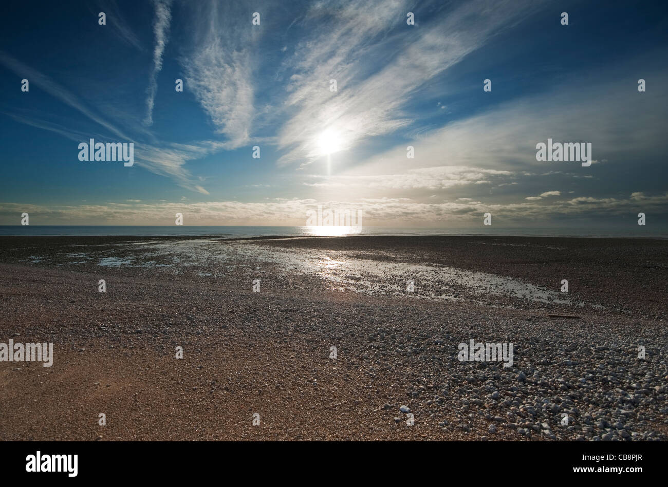 The shingle beach at Cuckmere Haven under an Autumn sky at low tide in ...