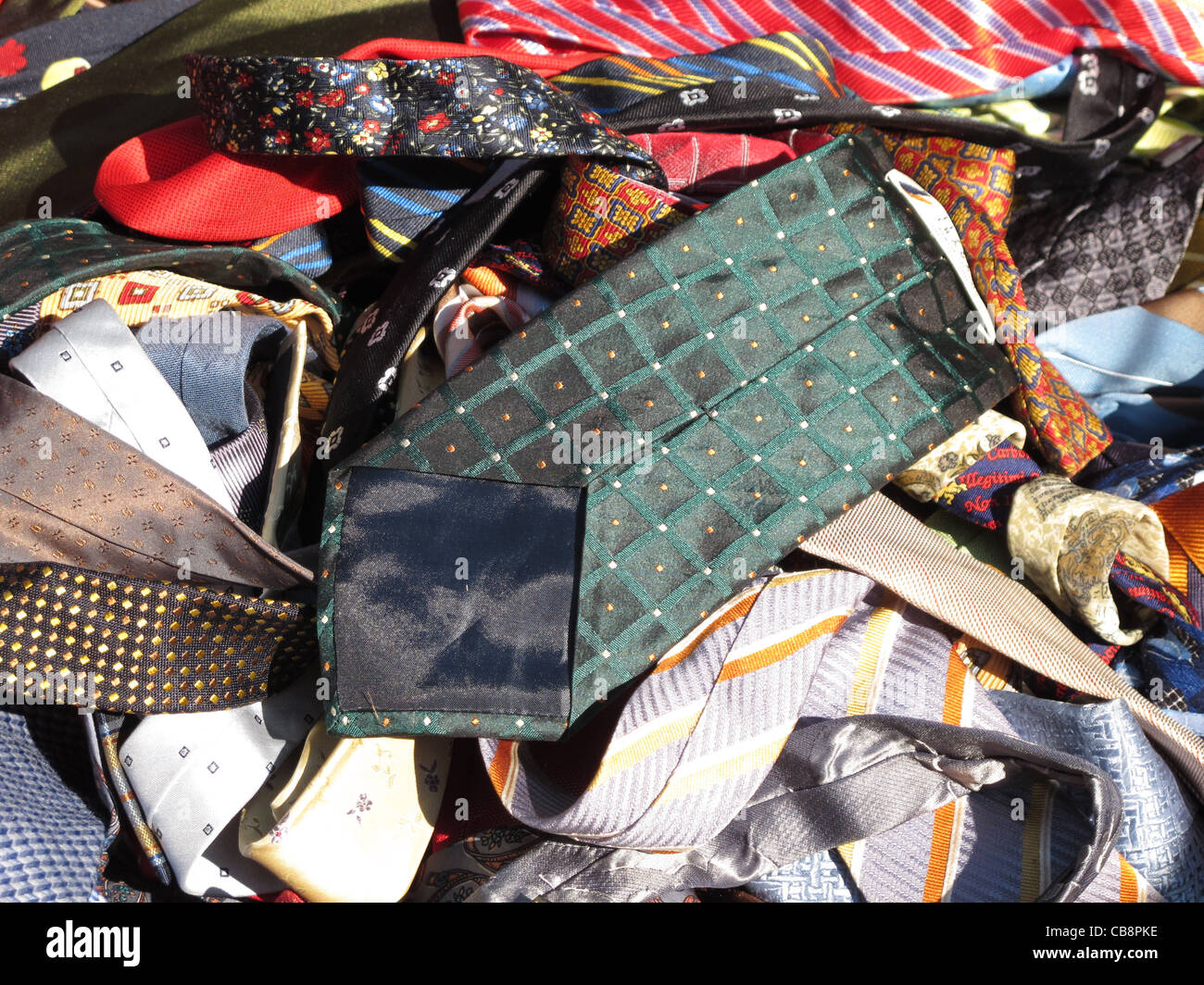 pile of second hand neck ties for sale on market stall stand outdoors ...