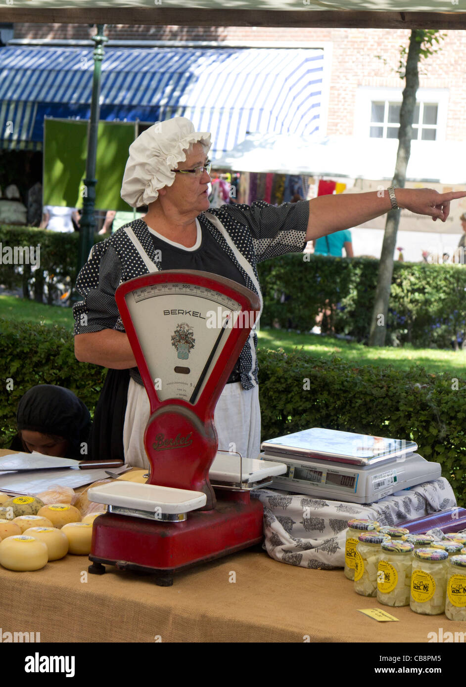 Stallholder selling cheese at a traditional costume market in the town ...