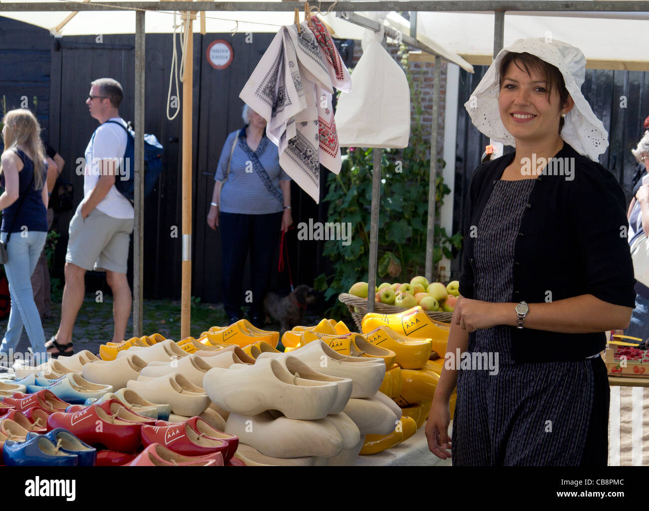 Portrait of a woman in traditional dutch costume selling clogs at a ...
