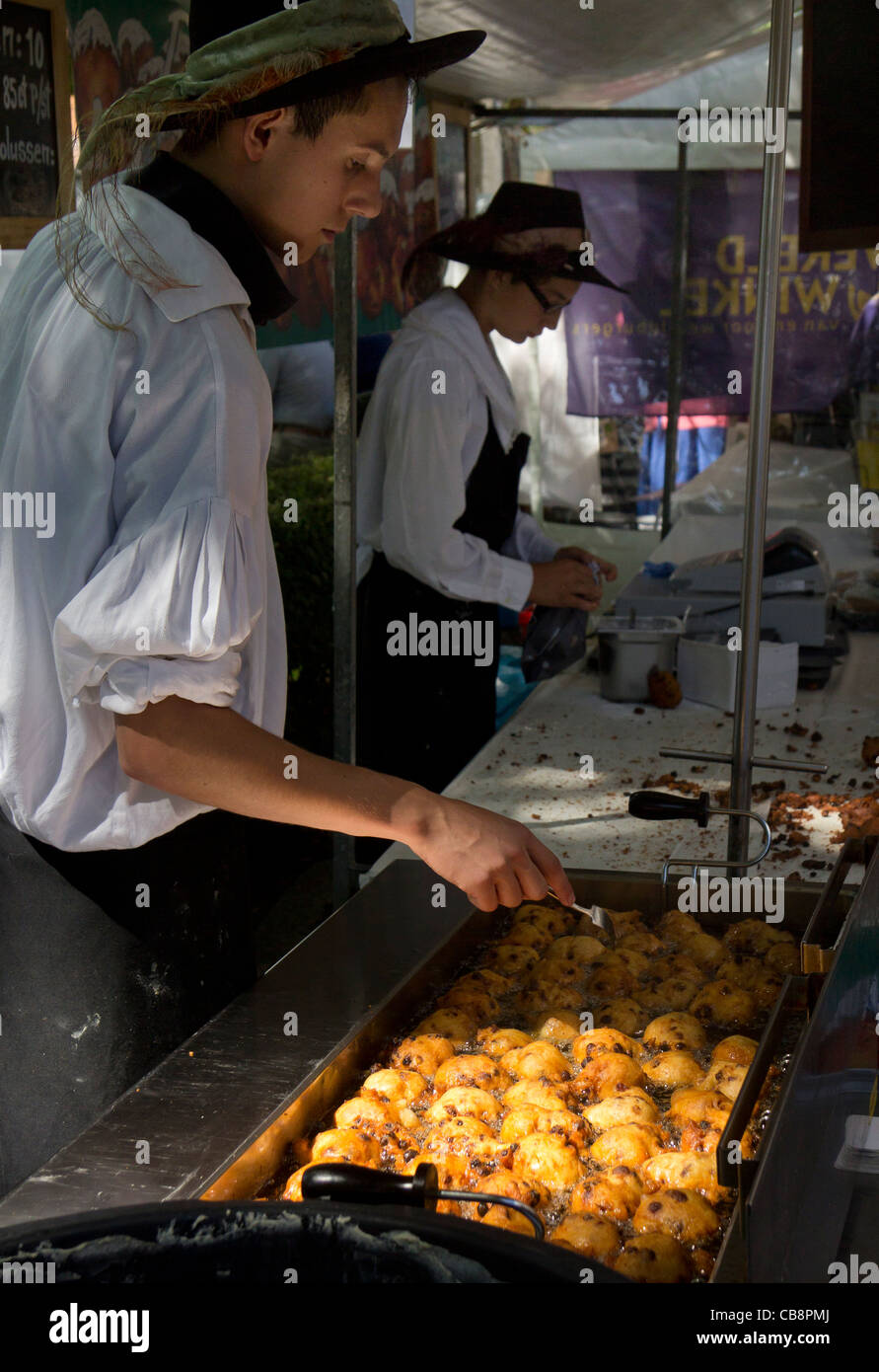Ollie-bollen or dutch doughnuts being deep fried at a traditional ...