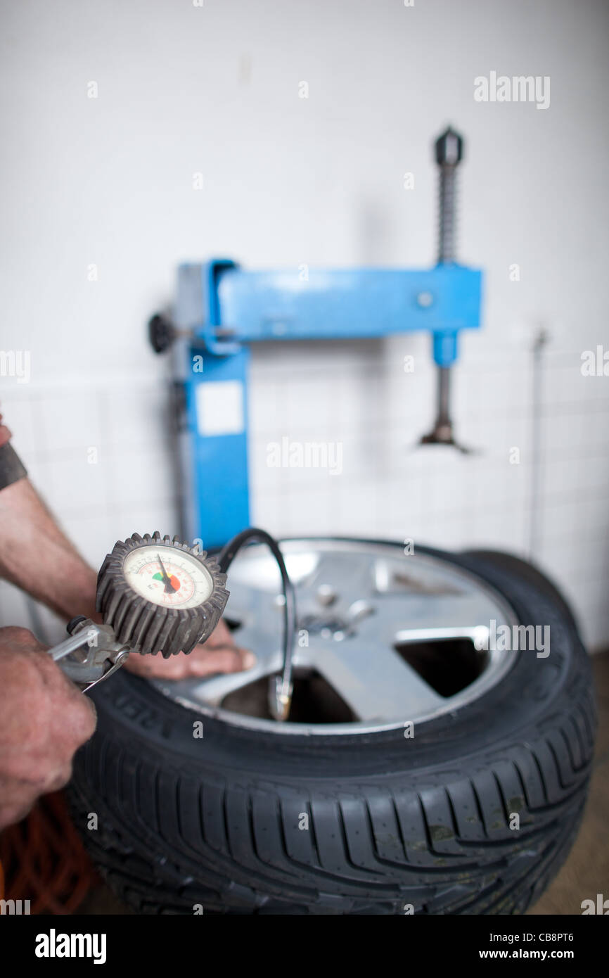 mechanic changing a wheel of a modern car (shallow DOF; color toned ...