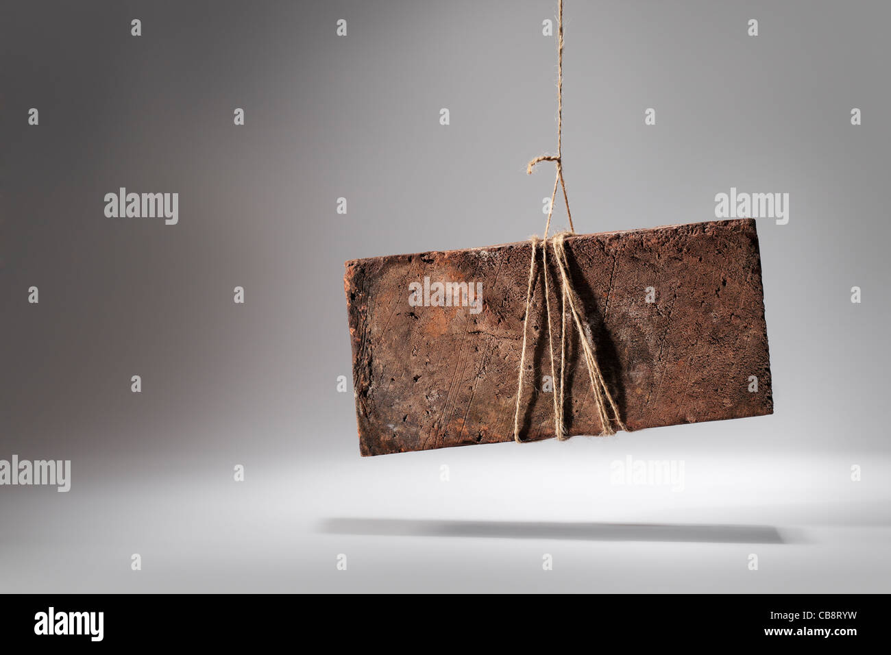 Old worn and weathered brick hanging by a string Stock Photo - Alamy