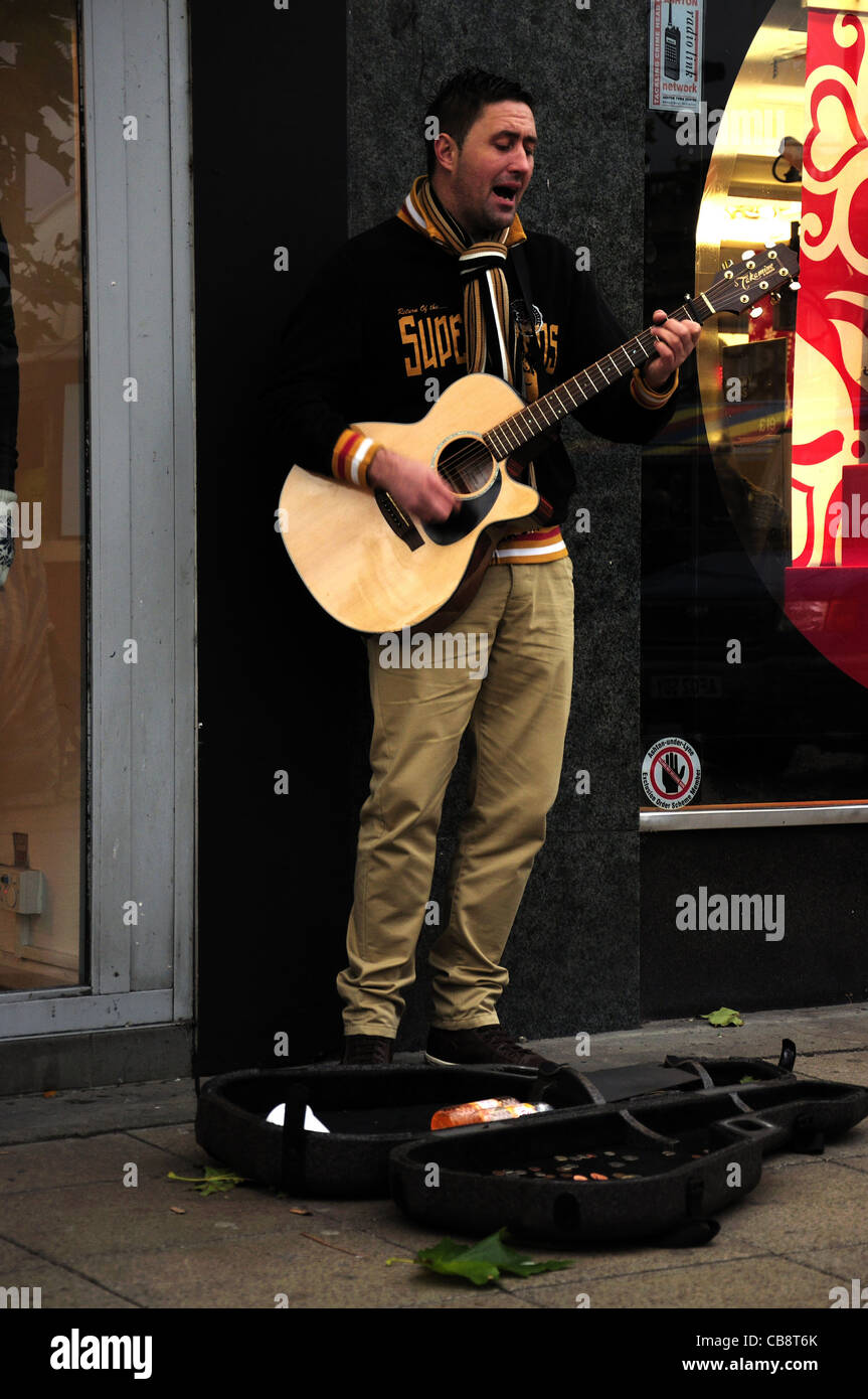 Male street busker with guitar singing Stock Photo - Alamy