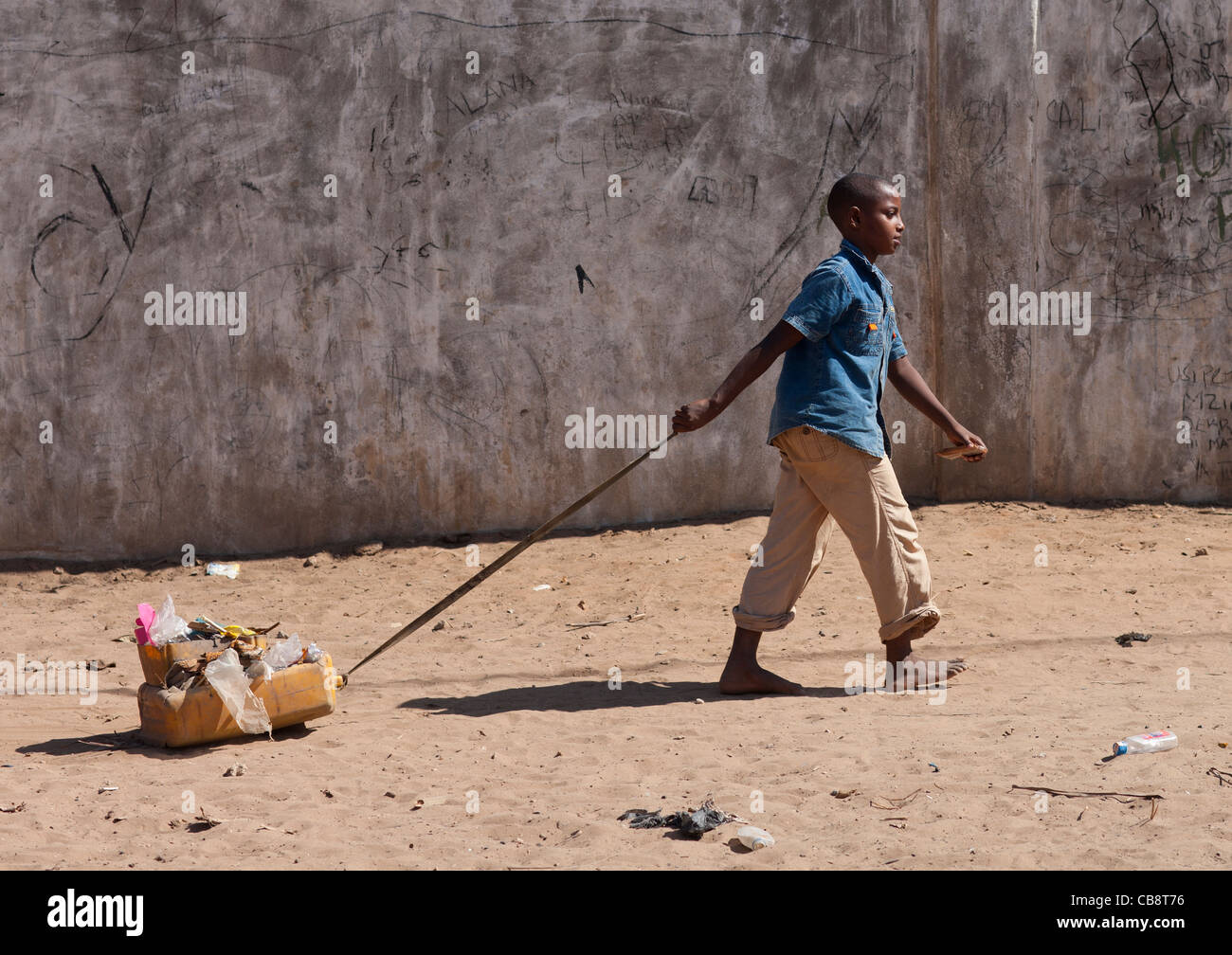Little Boy Dragging Trash In Sandy Street, Lamu, Kenya Stock Photo - Alamy