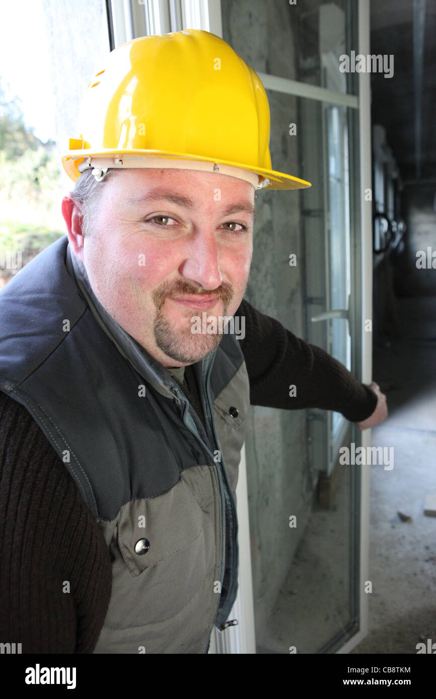 Builder installing double glazing Stock Photo - Alamy