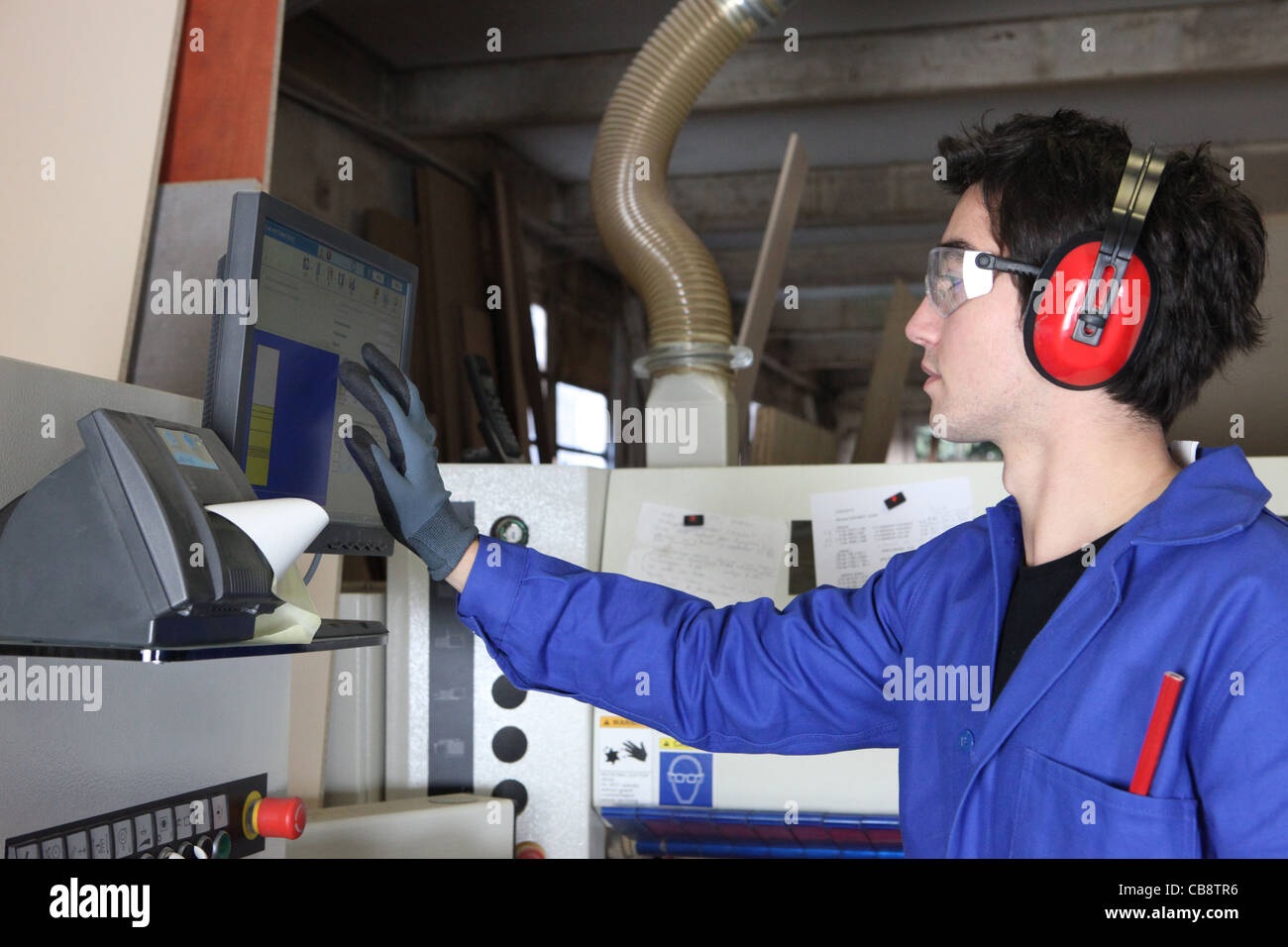 Young man operating factory machinery Stock Photo - Alamy