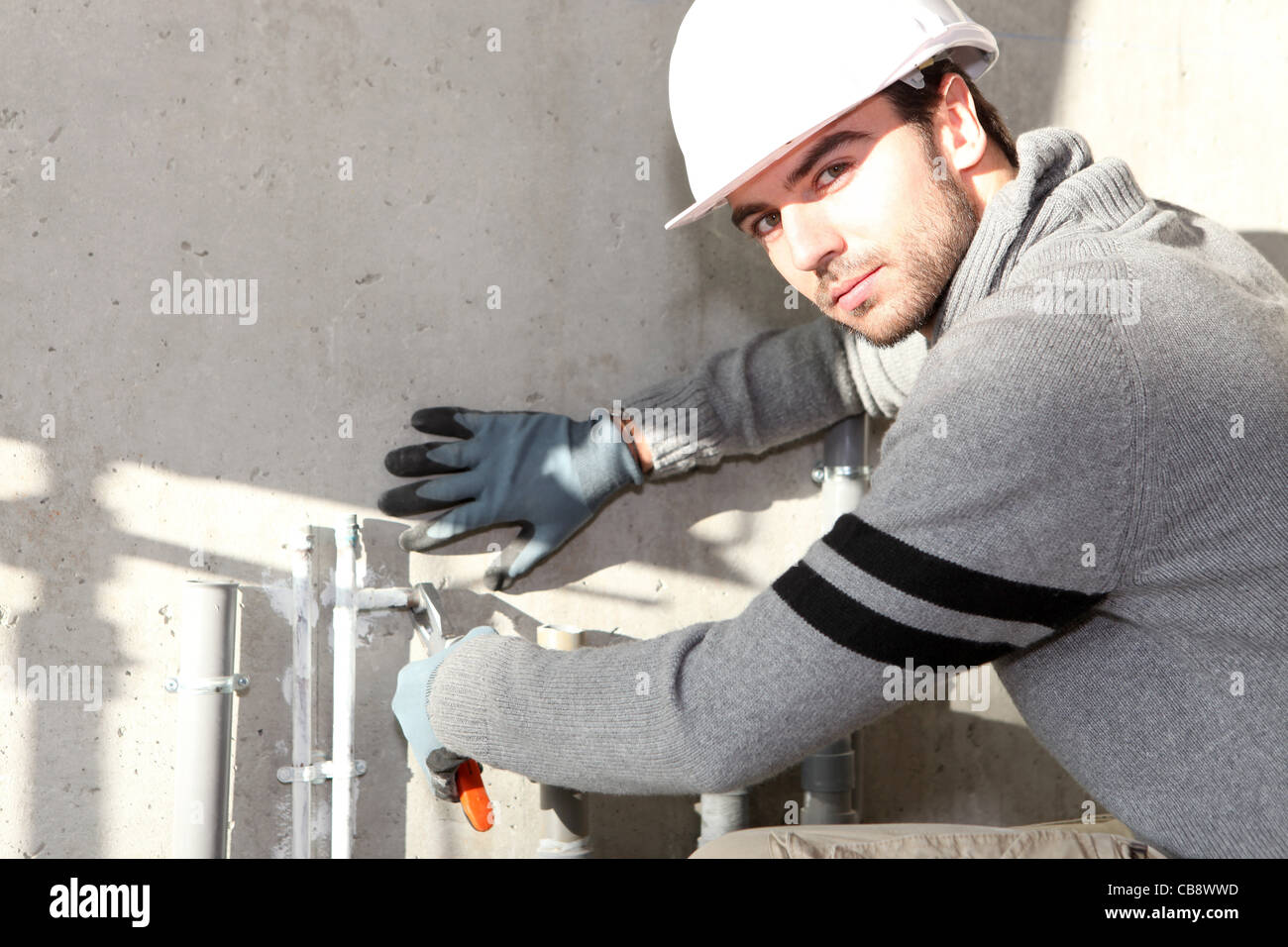 Builder cutting an outdoor pipe Stock Photo - Alamy