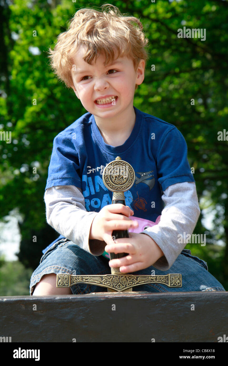 Little boy pulling the sword from the stone Stock Photo - Alamy