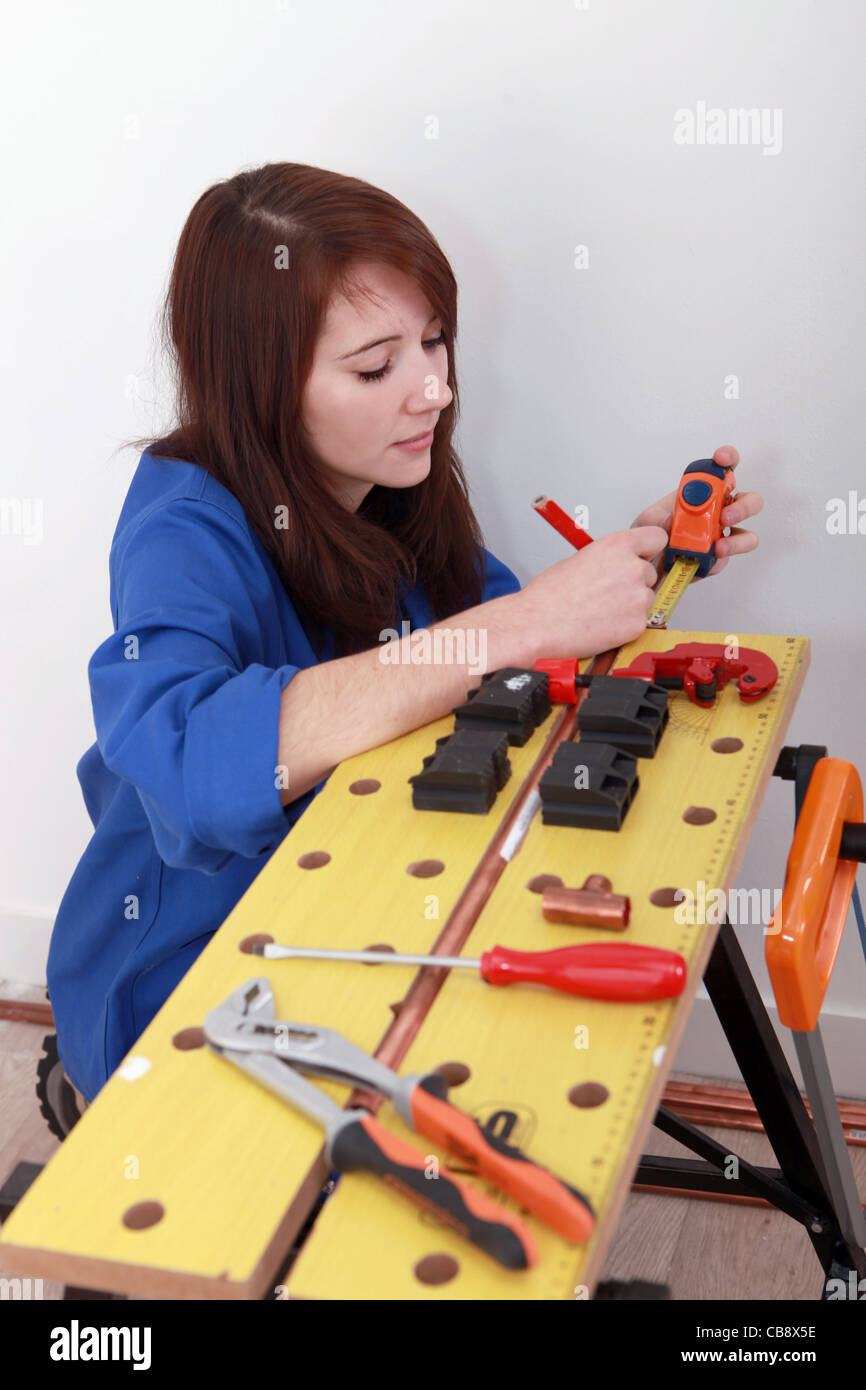 Female plumber measuring copper pipe Stock Photo - Alamy