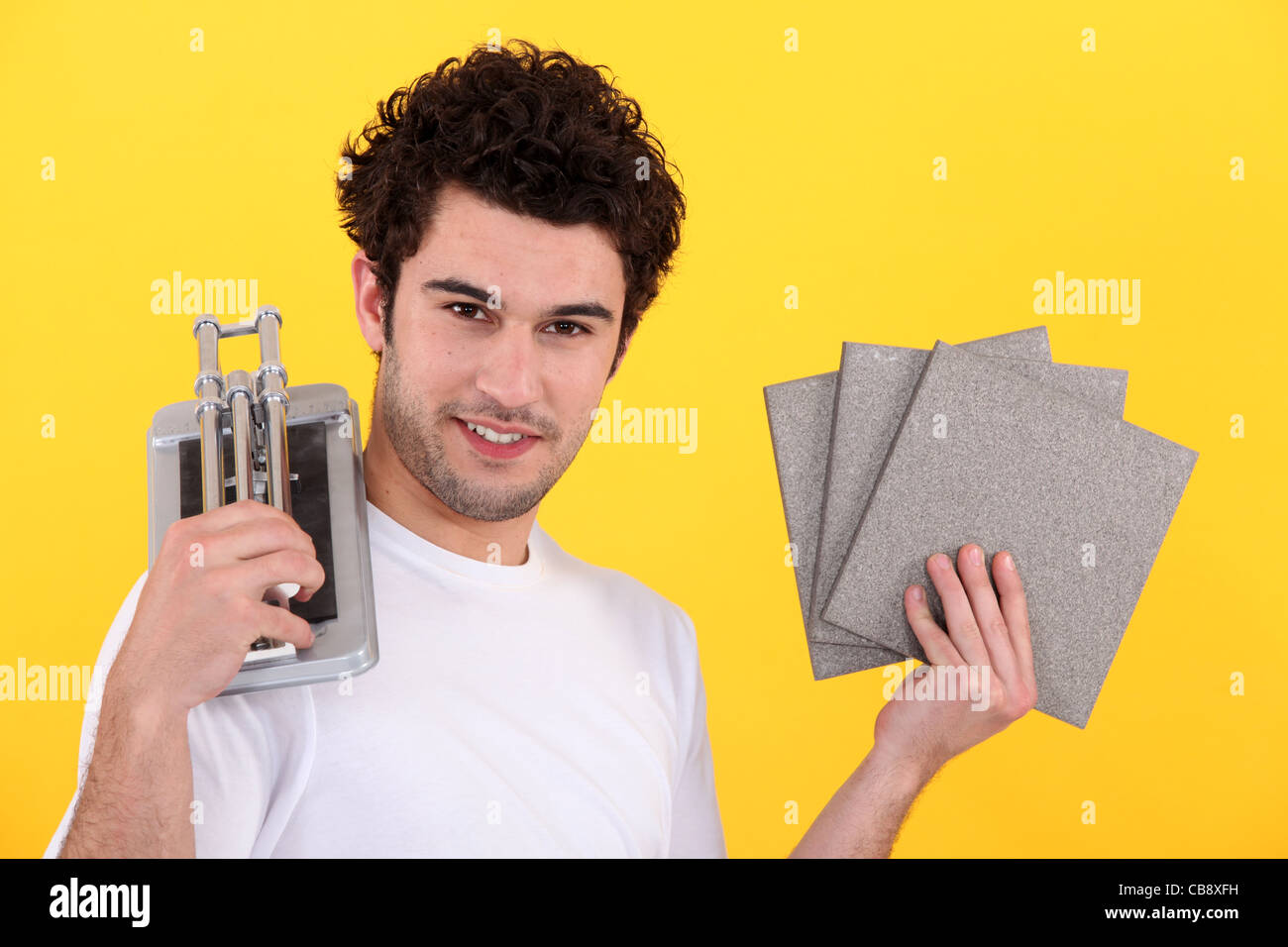 Man holder tiles and cutting device Stock Photo - Alamy