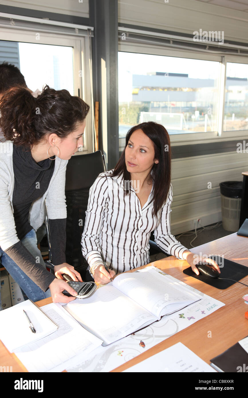 Woman asking her colleague a question Stock Photo - Alamy