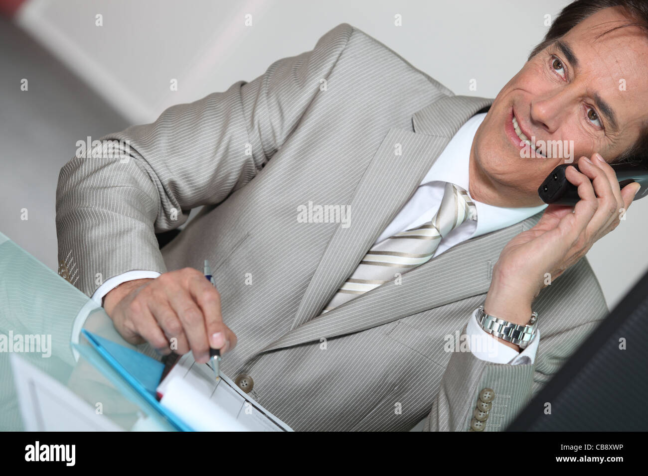 Businessman on the phone smiling Stock Photo - Alamy