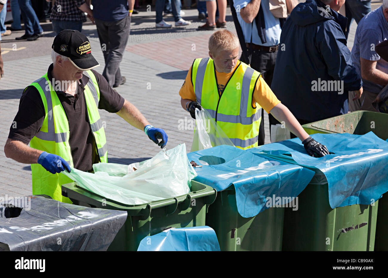 Men changing polythene liners on recycling disposal bins Abergavenny ...