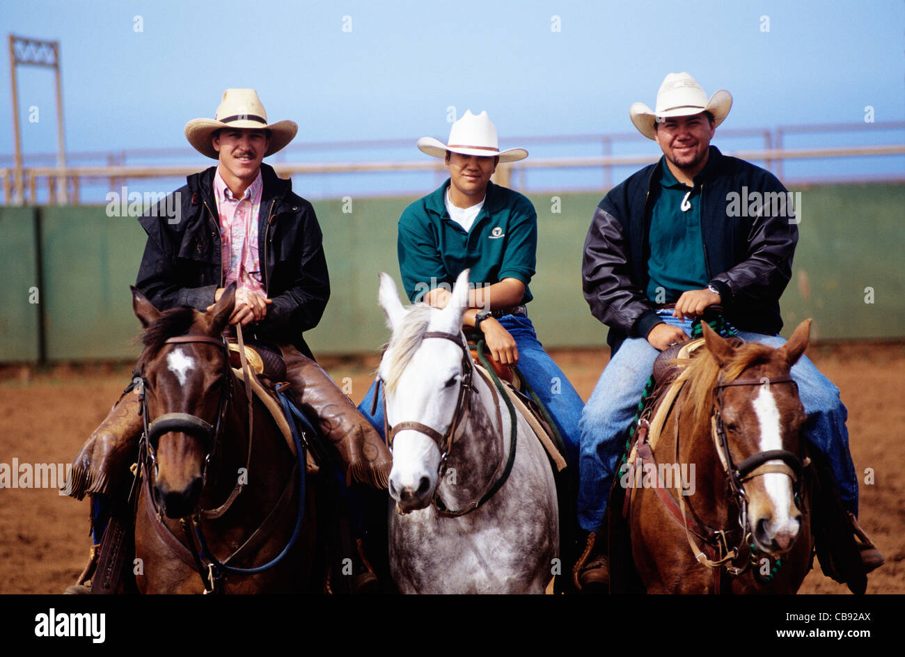 Hawaii, Molokai Ranch, paniolo pose for portrait on horseback in arena ...