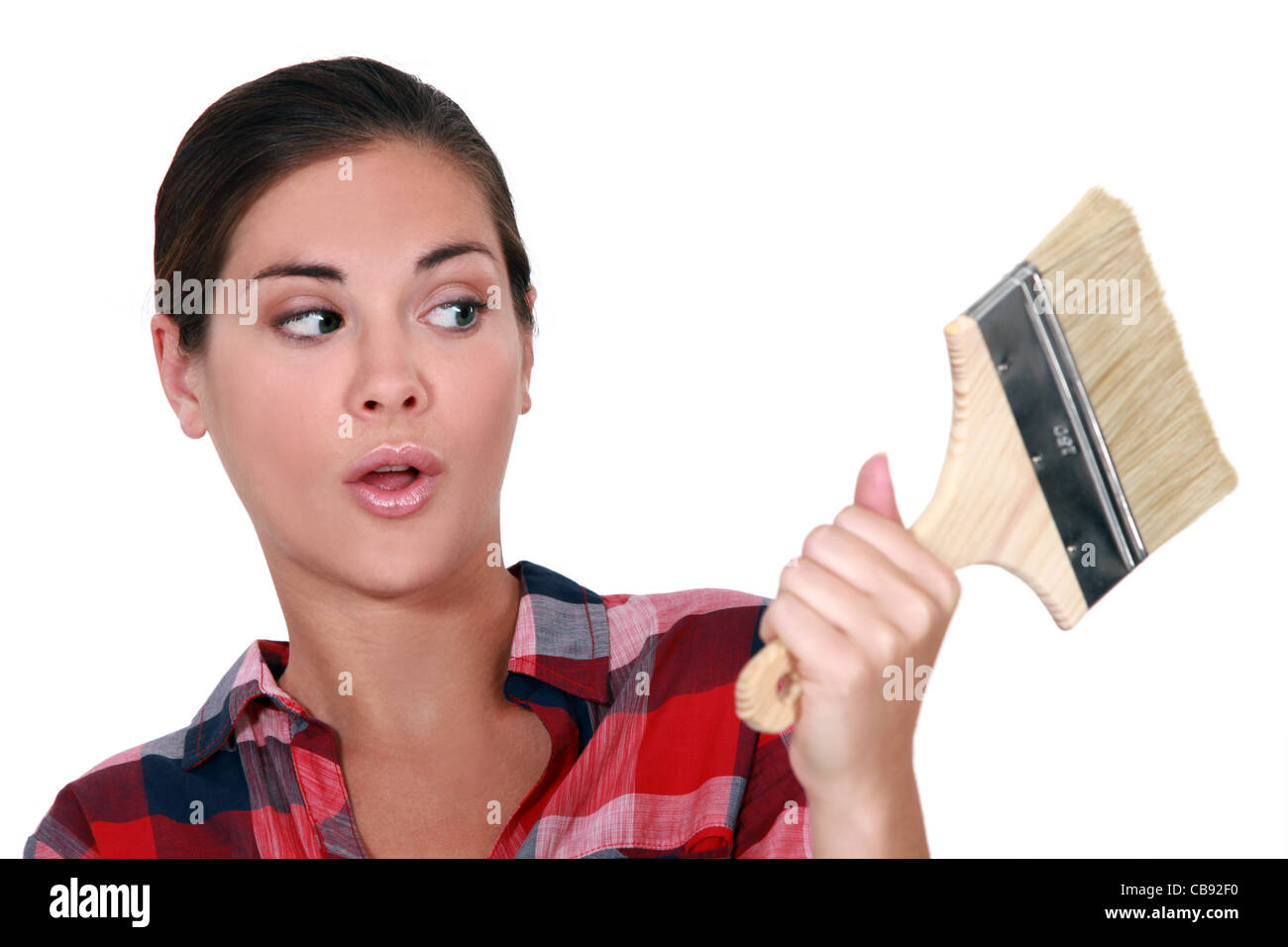 A female painter looking at a brush with a dubious look Stock Photo - Alamy