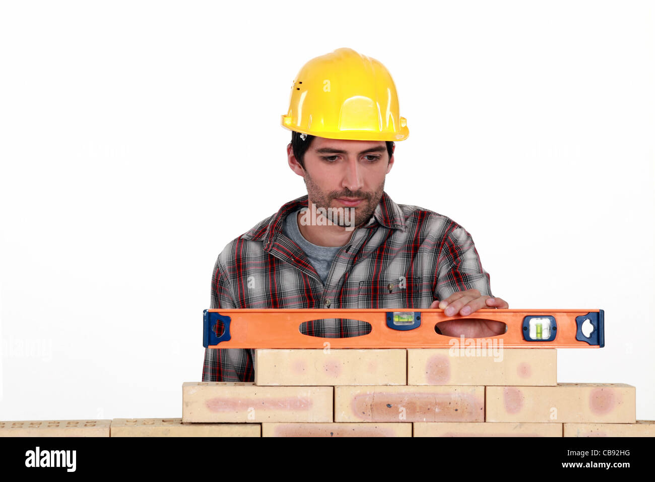 Mason checking level of a brick wall Stock Photo - Alamy