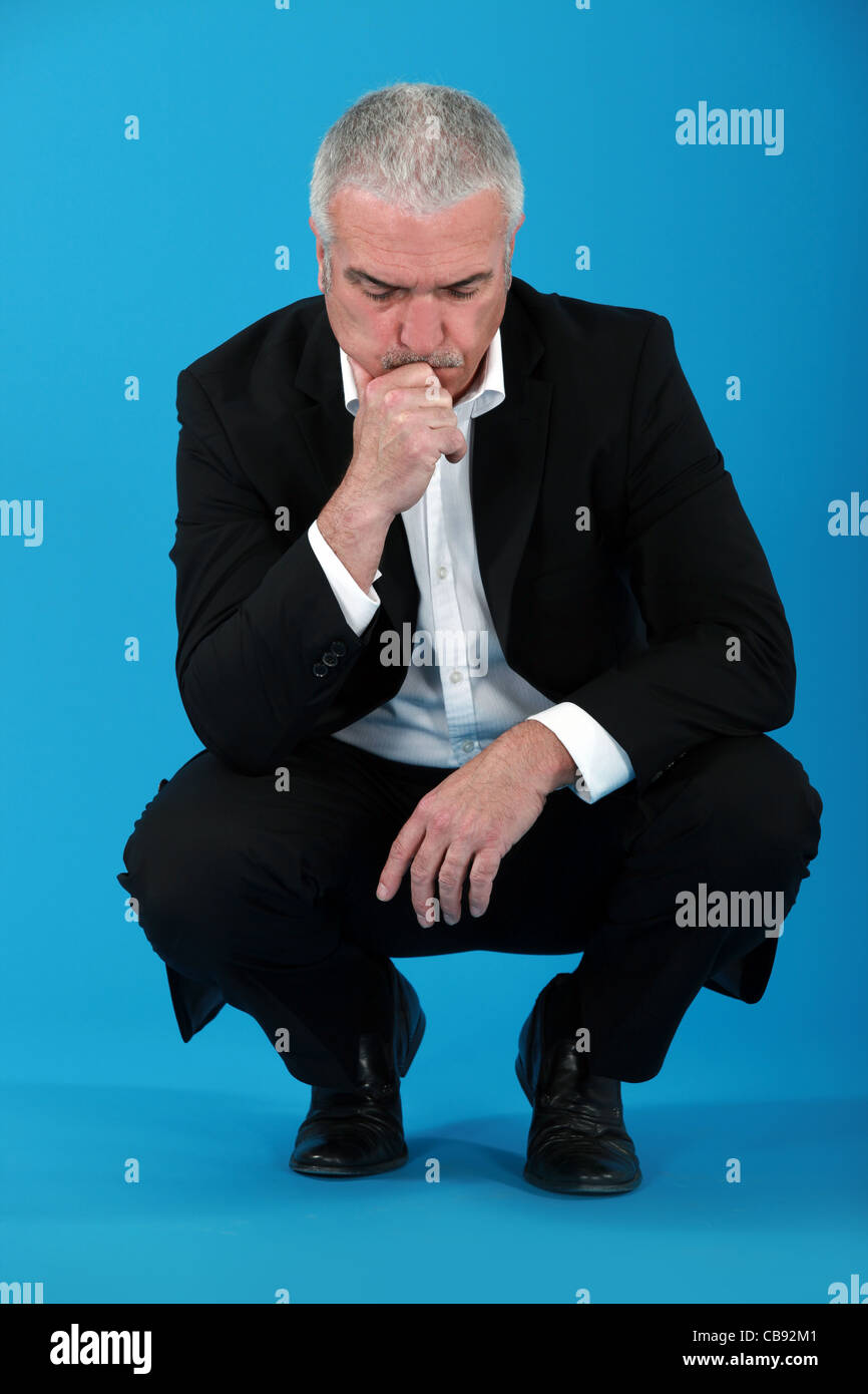 thoughtful mature man hunkering down Stock Photo - Alamy