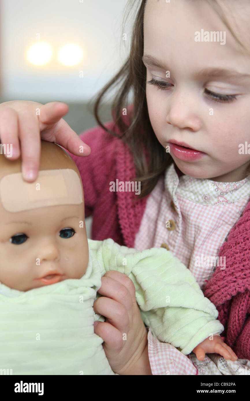 Child putting plaster on doll hi-res stock photography and images - Alamy