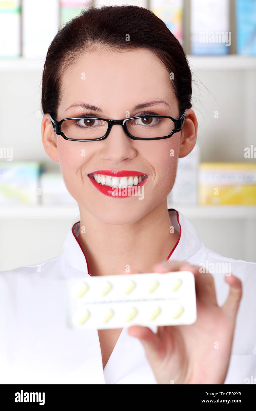 Pretty caucasian pharmacist showing pill blister Stock Photo - Alamy