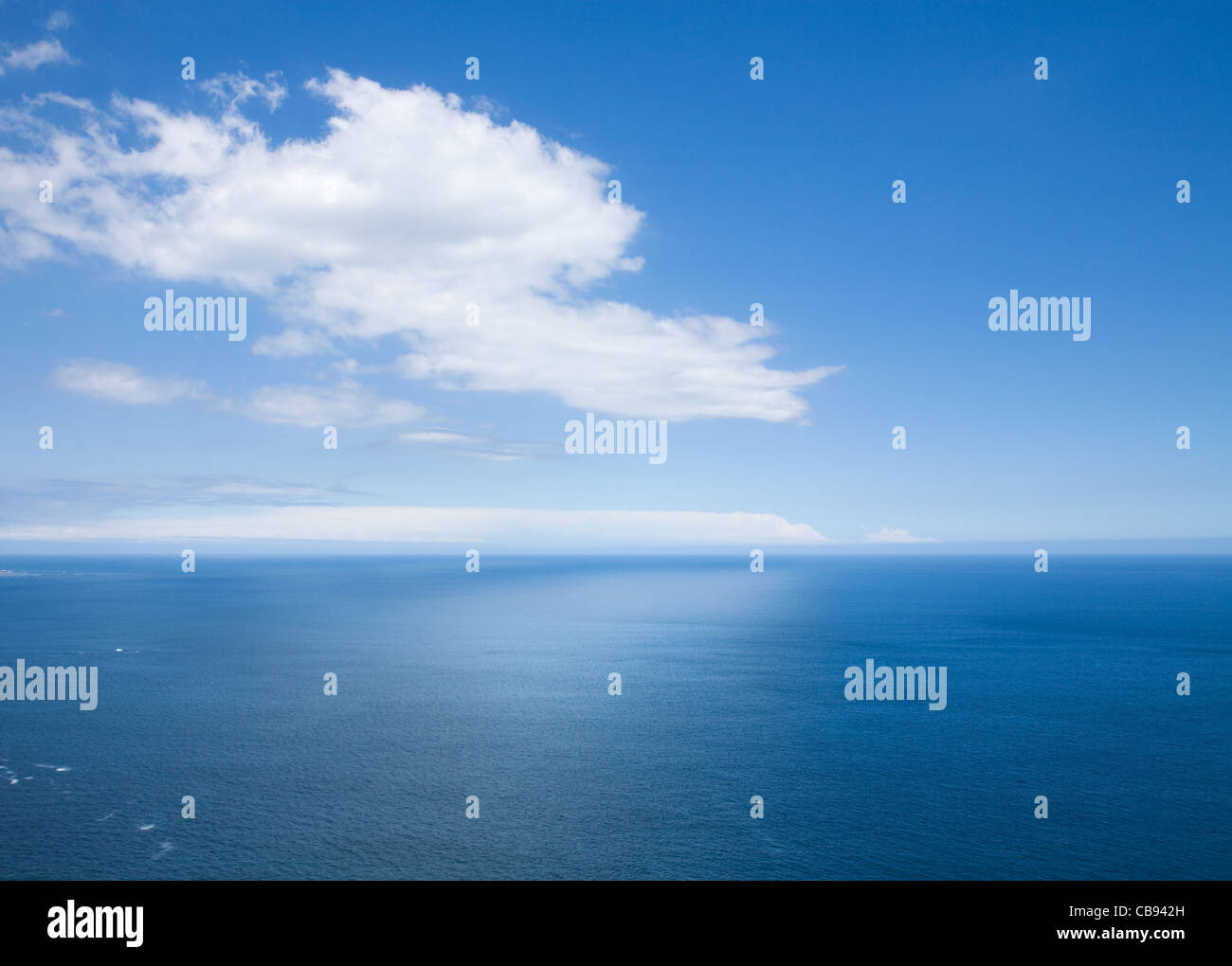 view over the ocean far below, white clouds and its reflection Stock ...