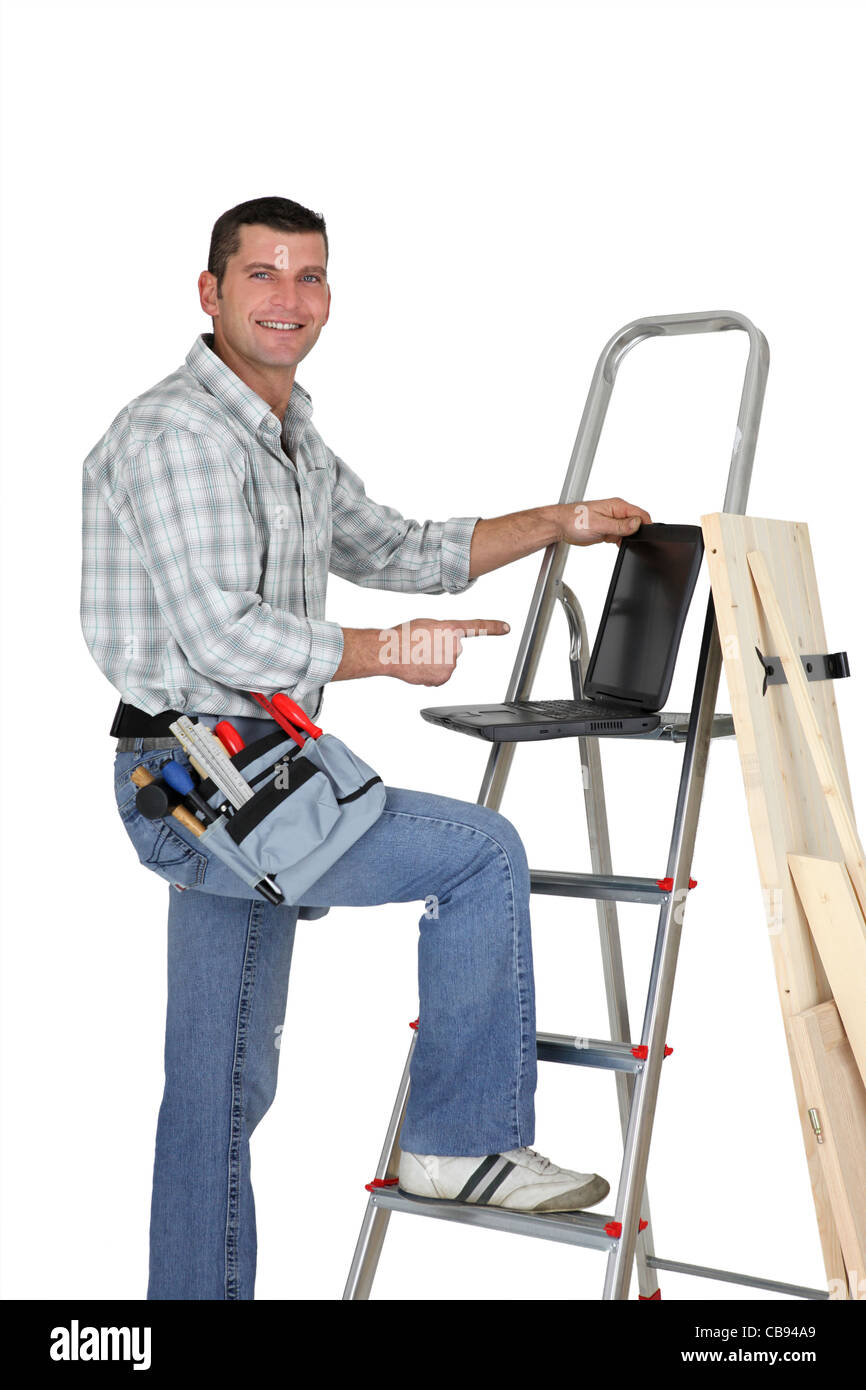 Builder with wood and a laptop Stock Photo - Alamy