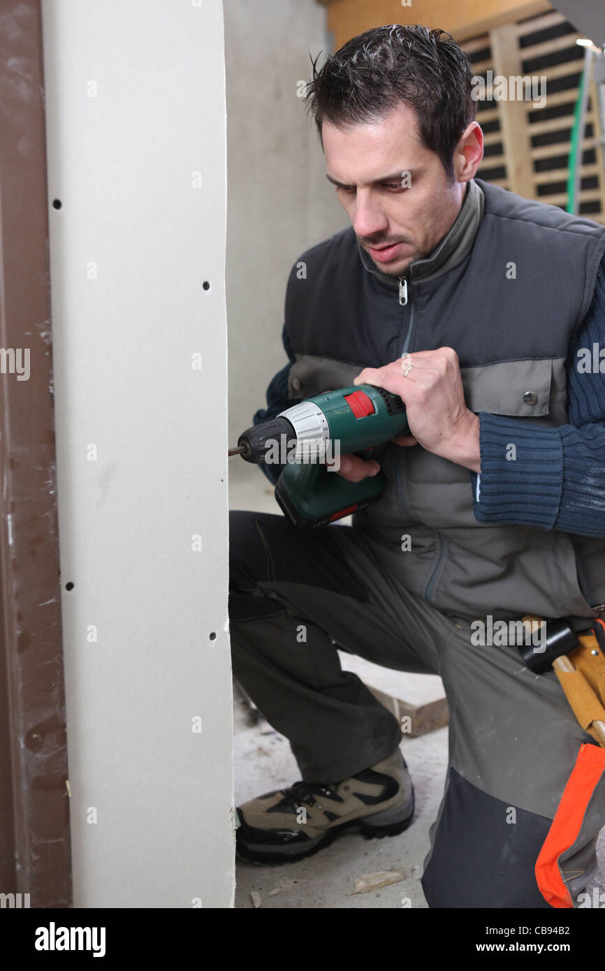 Man drilling an interior wall Stock Photo - Alamy