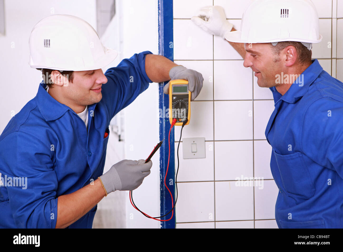 couple of electricians working Stock Photo - Alamy