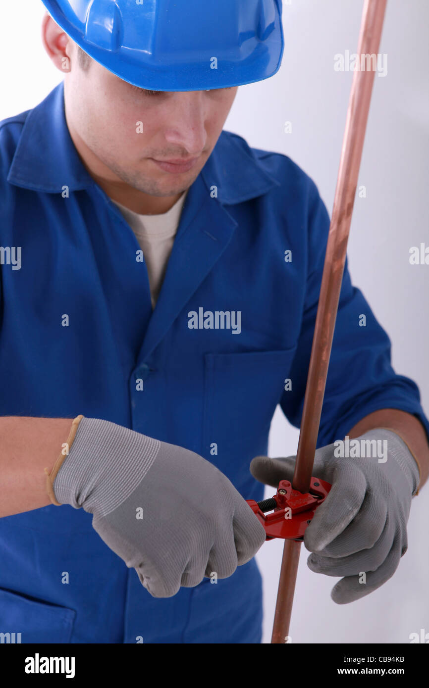 Plumber cutting copper pipe Stock Photo - Alamy