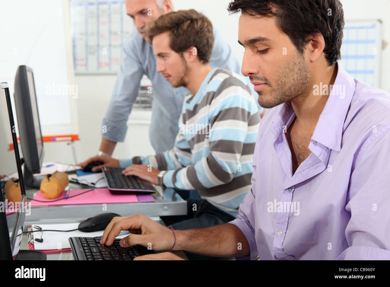 Young men working on computers Stock Photo - Alamy