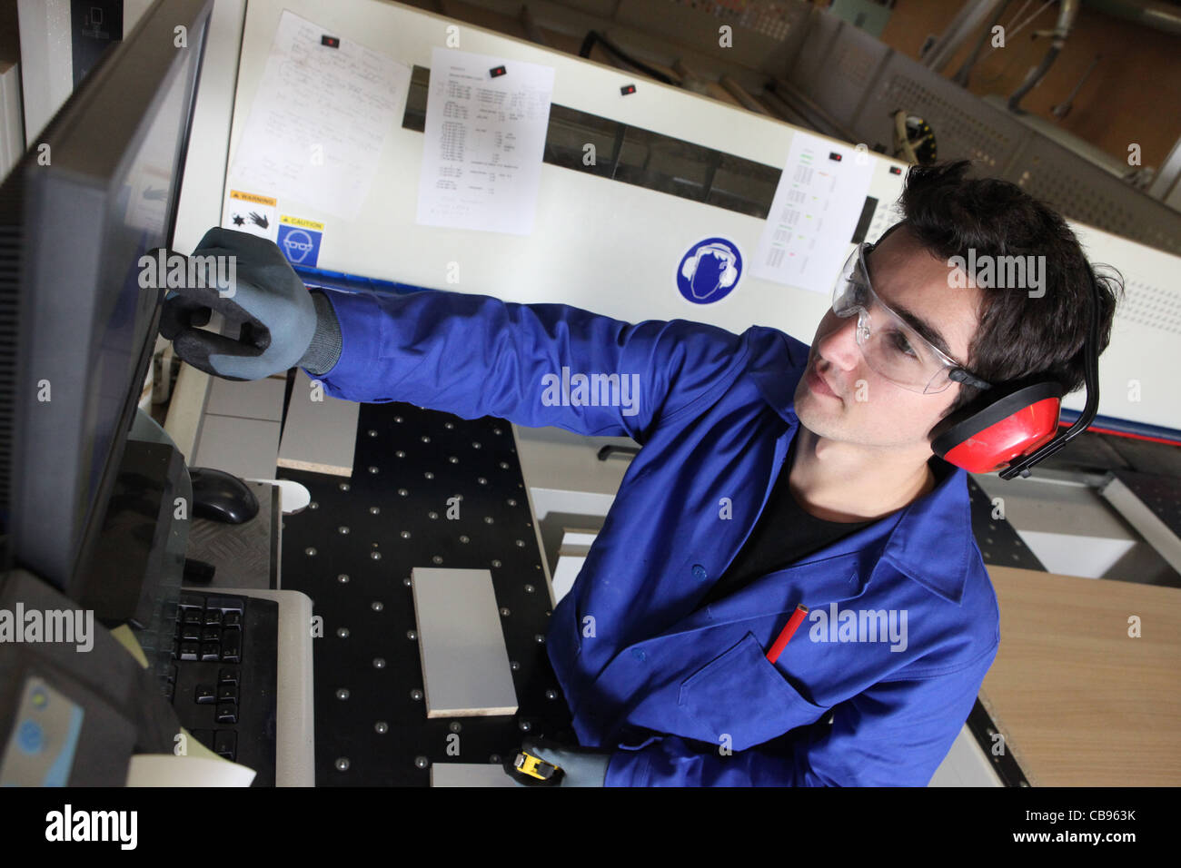 young blue collar in factory with computer Stock Photo - Alamy
